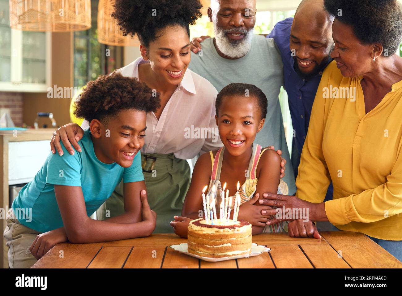 Multi-Generation Family Celebrating Granddaughter's Birthday With Cake And Candles At Home Stock ...