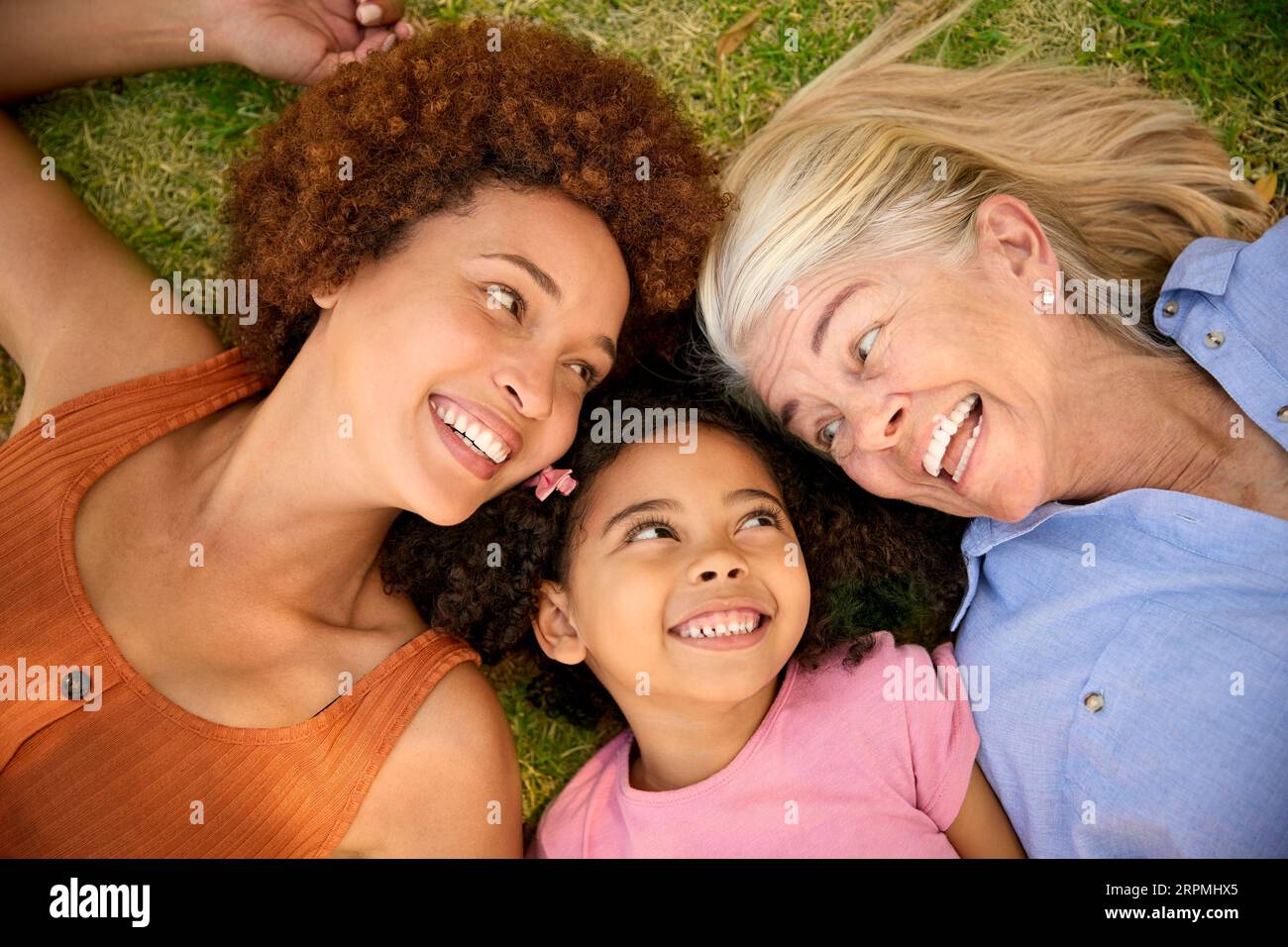 Overhead Portrait Shot Of Multi-Generation Female Family Lying On Grass ...