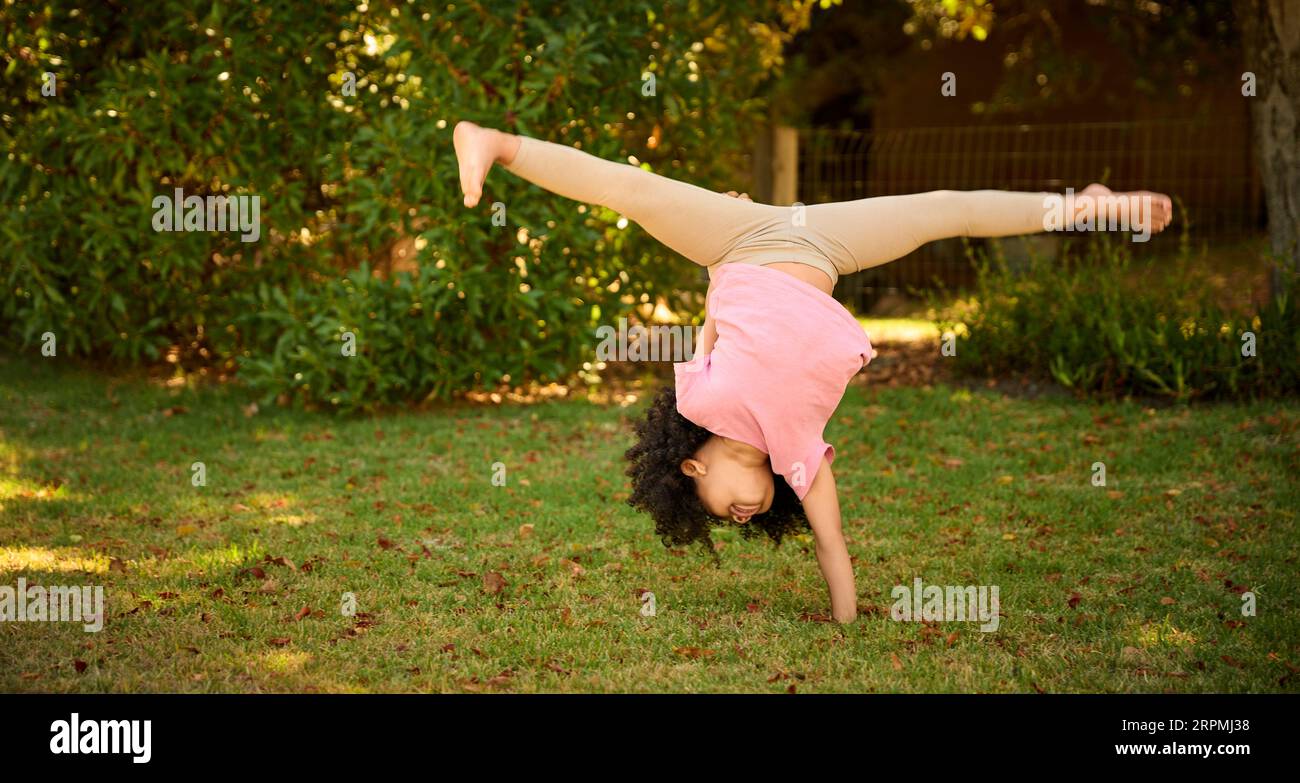 Active Young Girl Having Fun Turning Cartwheels Playing In Garden At ...
