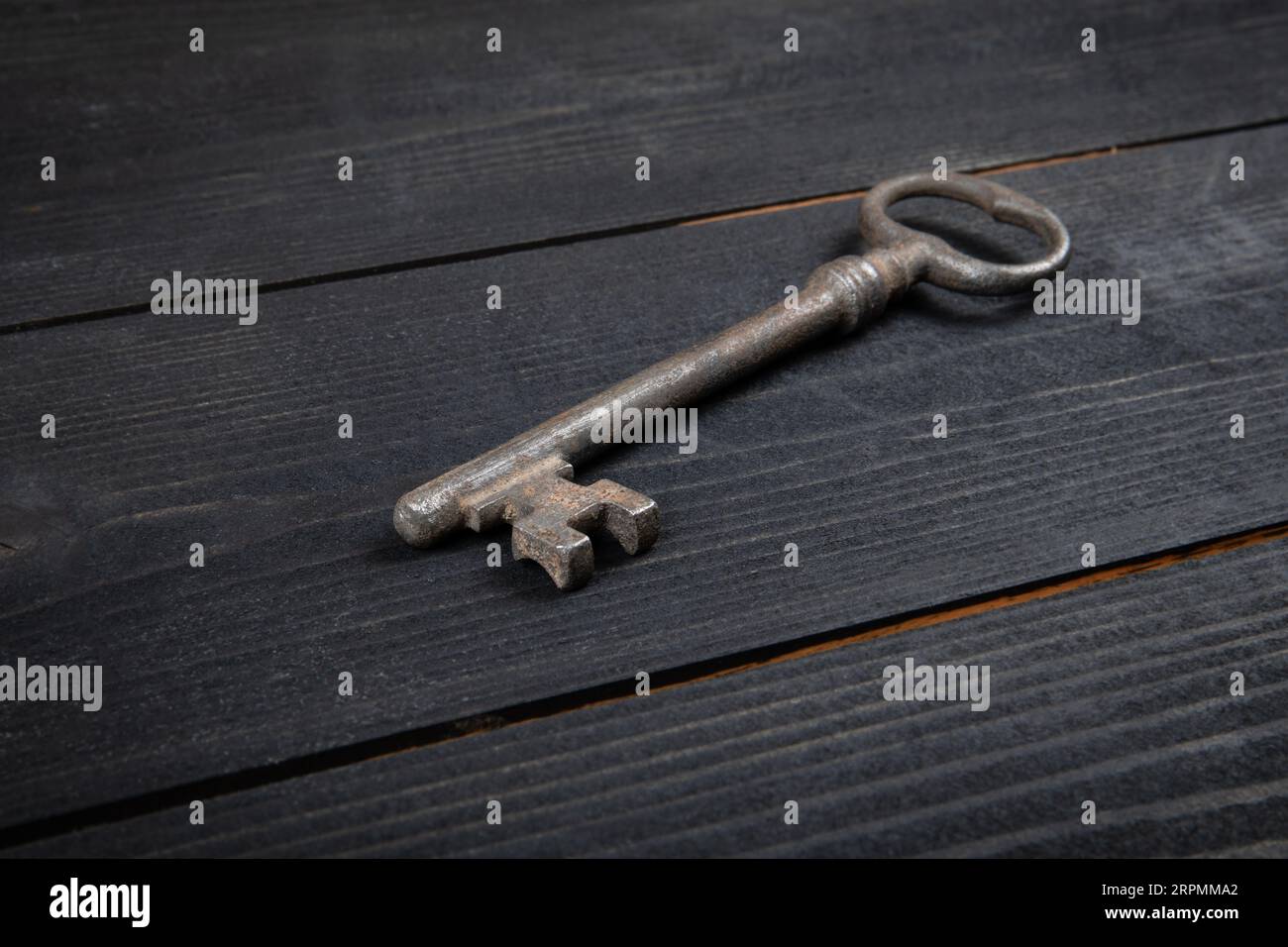 Old rusty key on dark wood texture background Stock Photo - Alamy