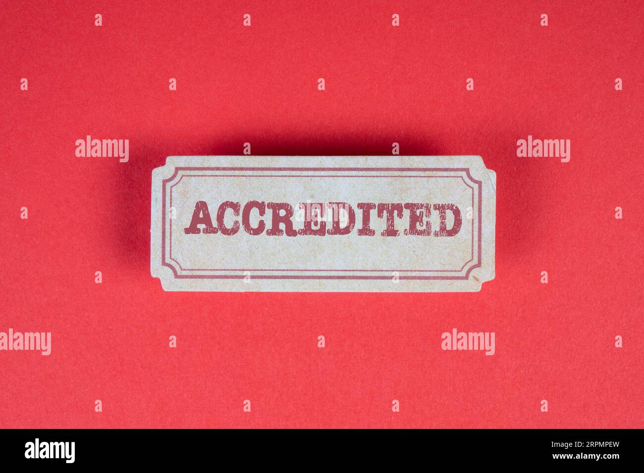 ACCREDITED. Cardboard sticker with text on a red background Stock Photo ...