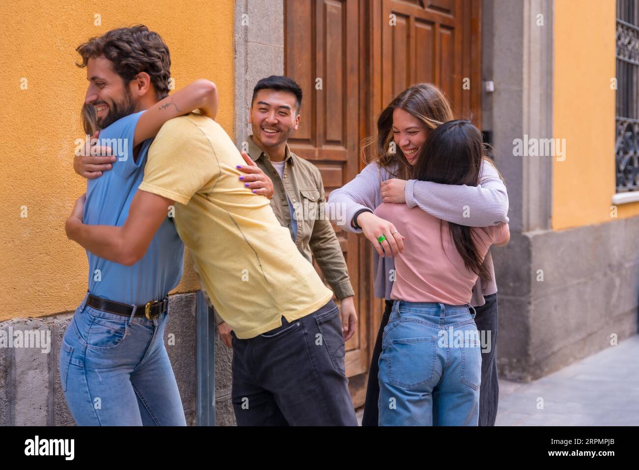 Group of multiracial friends greeting and kissing in the city ...