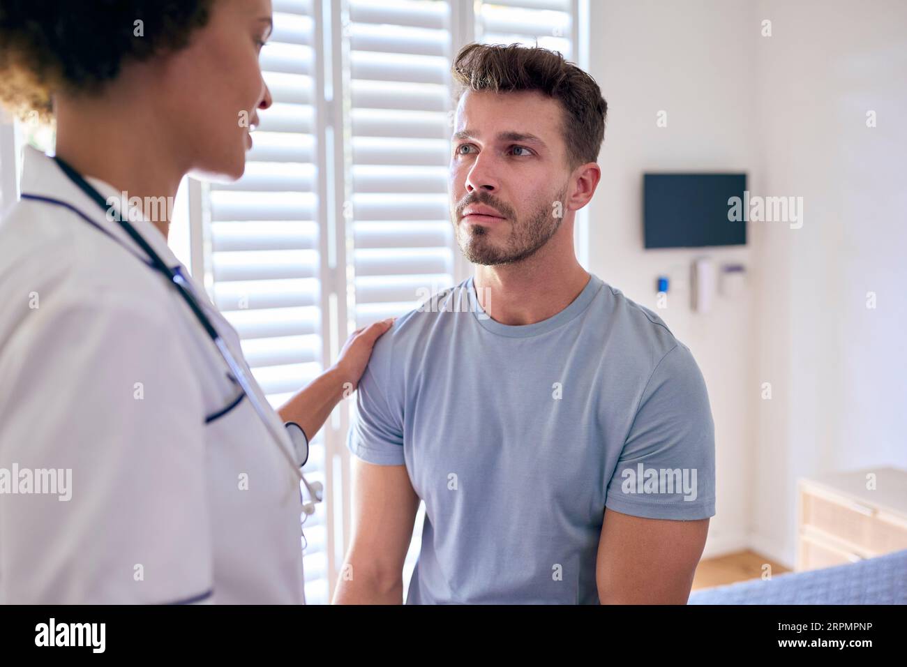 Female Nurse Wearing Uniform Giving Male Patient Bad News In Private ...