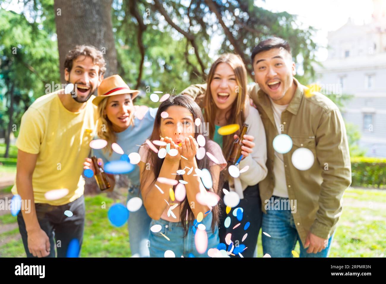 Portrait multiethnic group of partying throwing confetti smiling in ...
