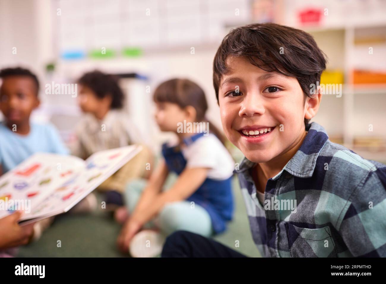 Portrait Of Smiling Male Elementary School Pupil Sitting In Classroom ...
