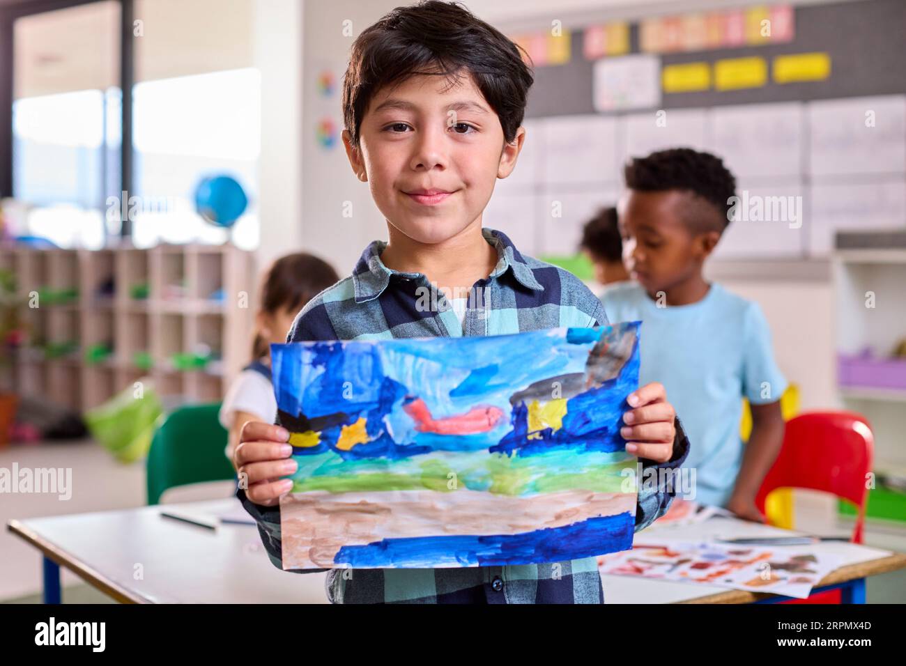 Classroom Portrait Of Proud Male Elementary School Pupil Holding ...