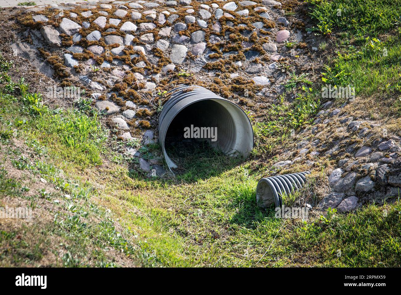Trough the pipe. Stormwater and road infrastructure ditch Stock Photo ...