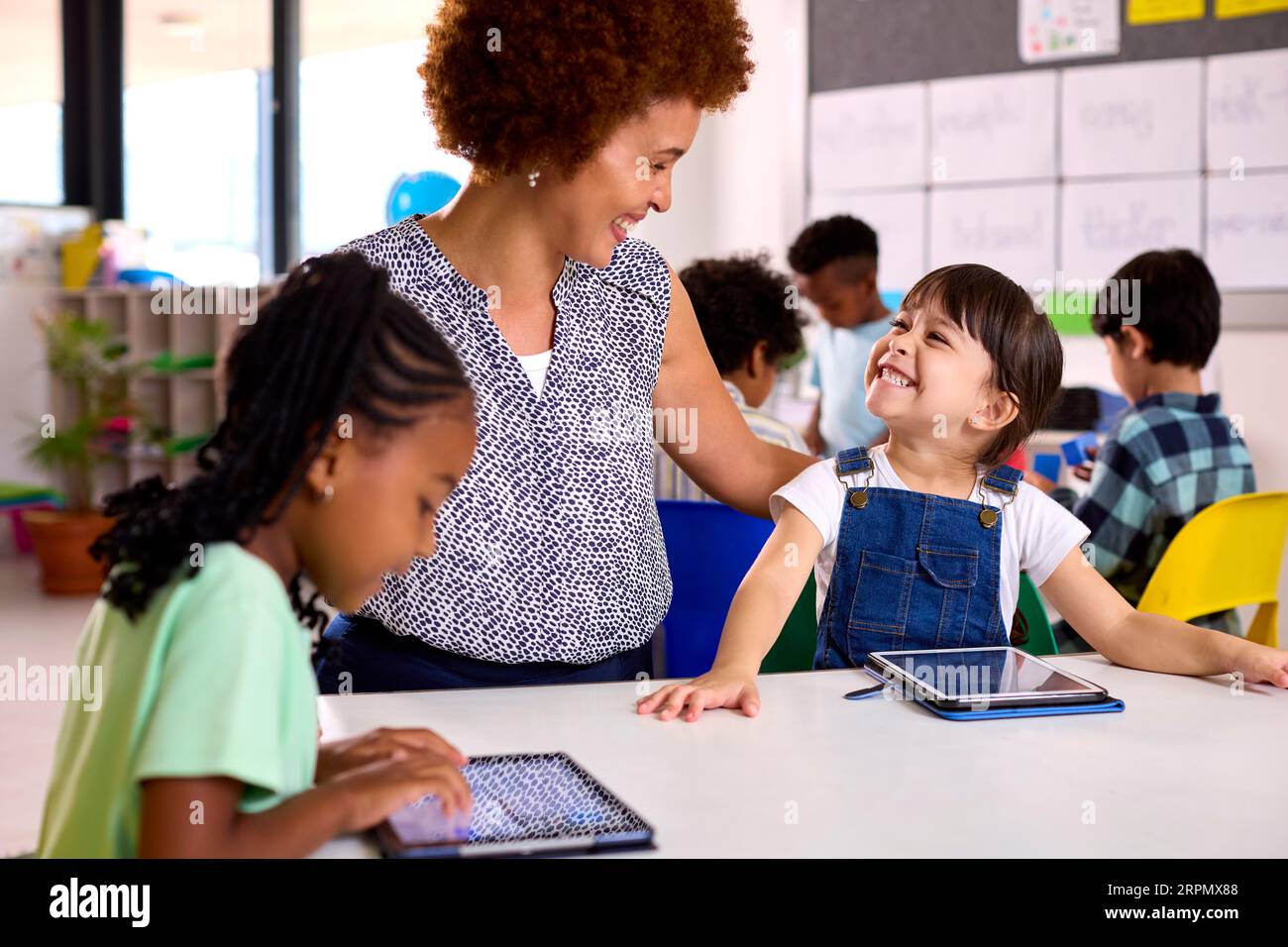 Female Teacher With Multi-Cultural Elementary School Pupils Using ...