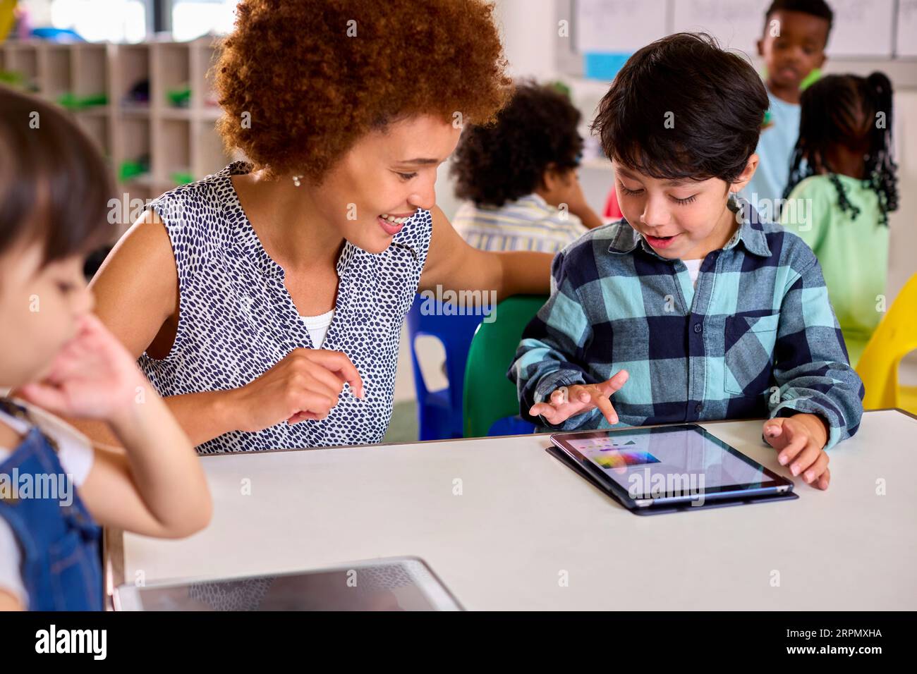 Female Teacher With Multi-Cultural Elementary School Pupils Using ...