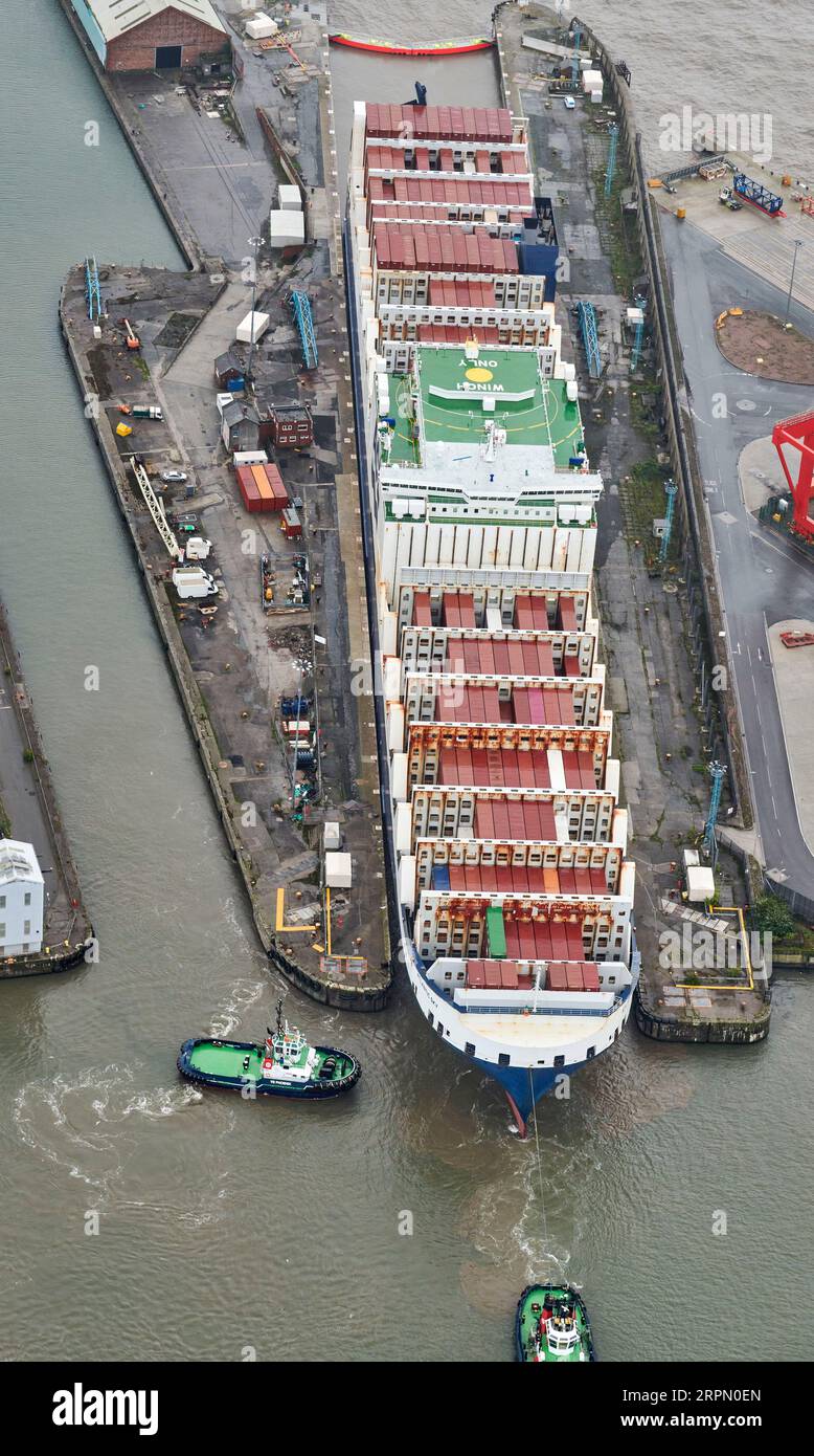 Tug boats guiding a container ship into Seaforth Docks, Liverpool ...