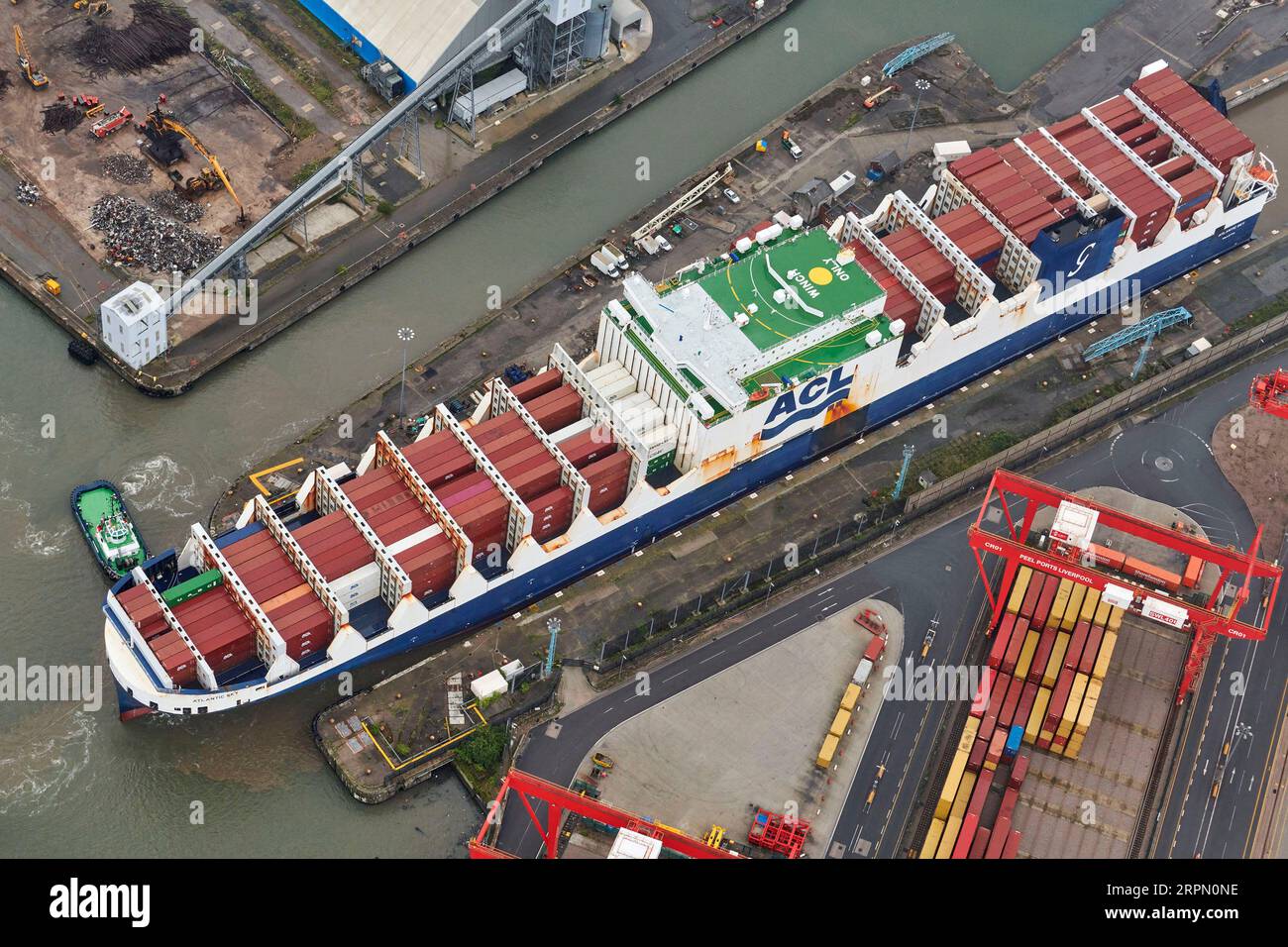 Tug boats guiding a container ship into Seaforth Docks, Liverpool ...