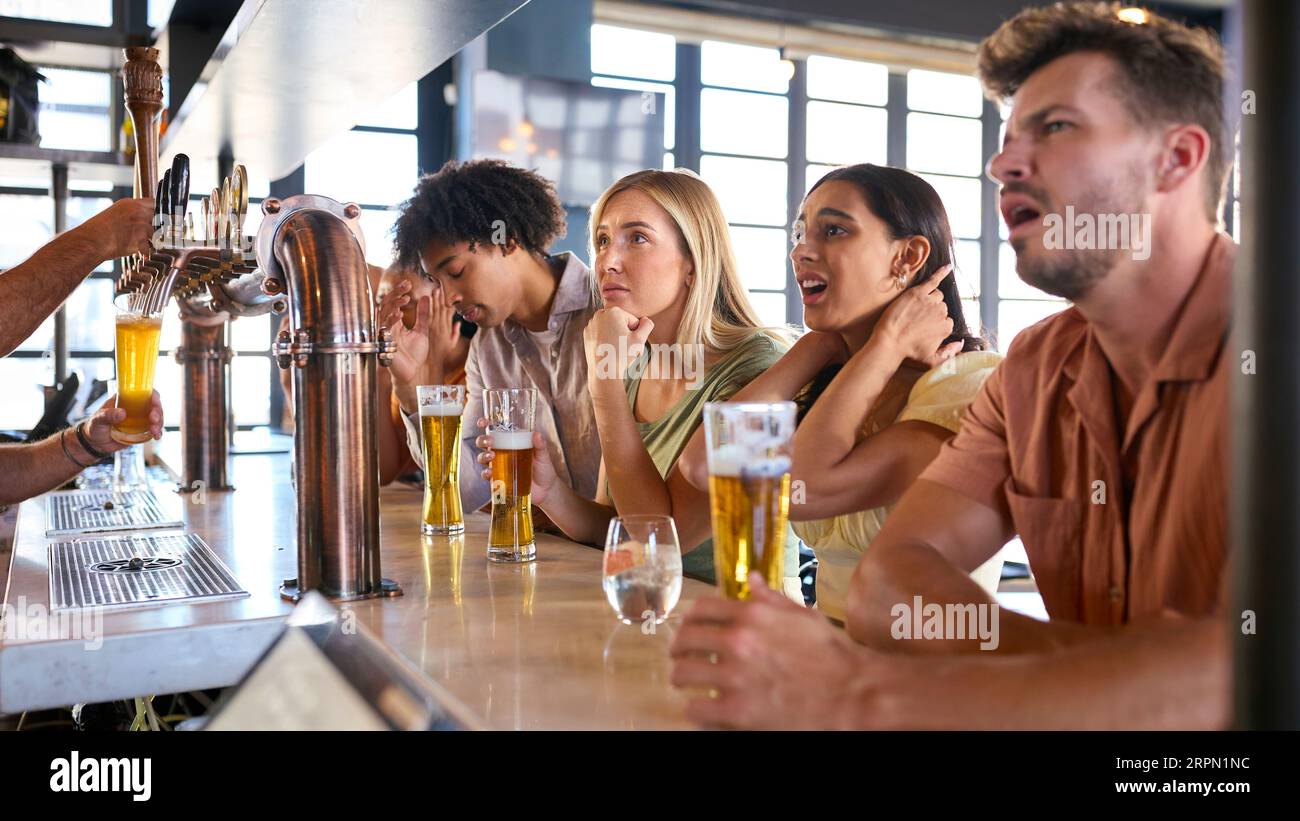Disappointed Multi-Cultural Group Of Friends In Sports Bar Watching ...