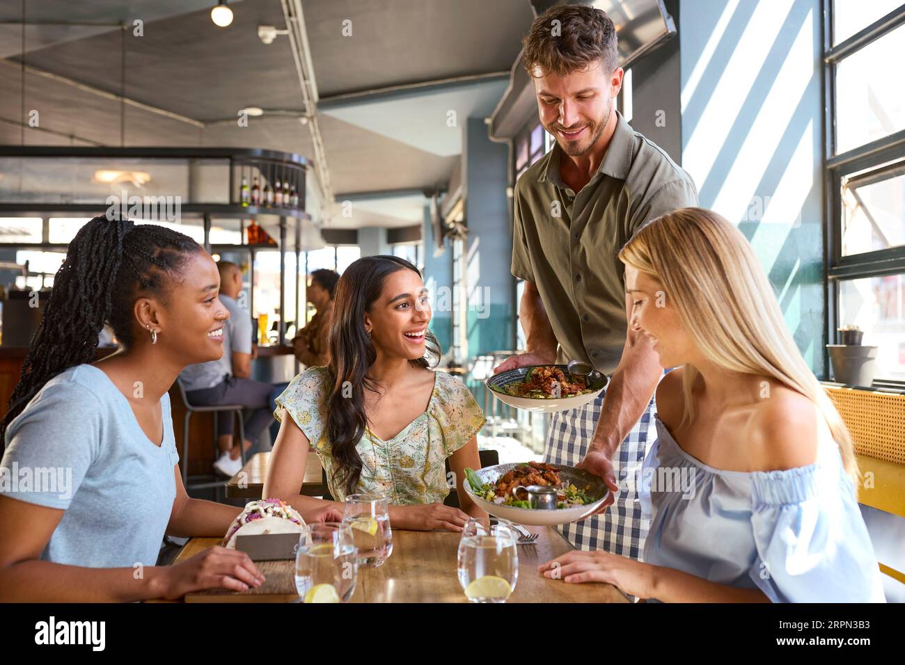 Group Of Female Friends Meeting Up In Restaurant Being Served Meal By ...