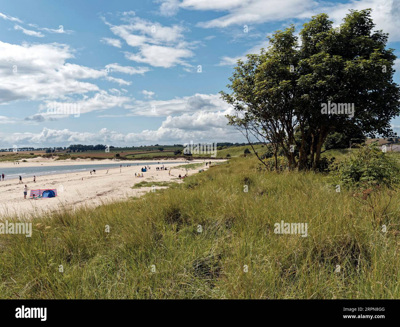 The view south along the sand dunes and beach towards the estuary of ...