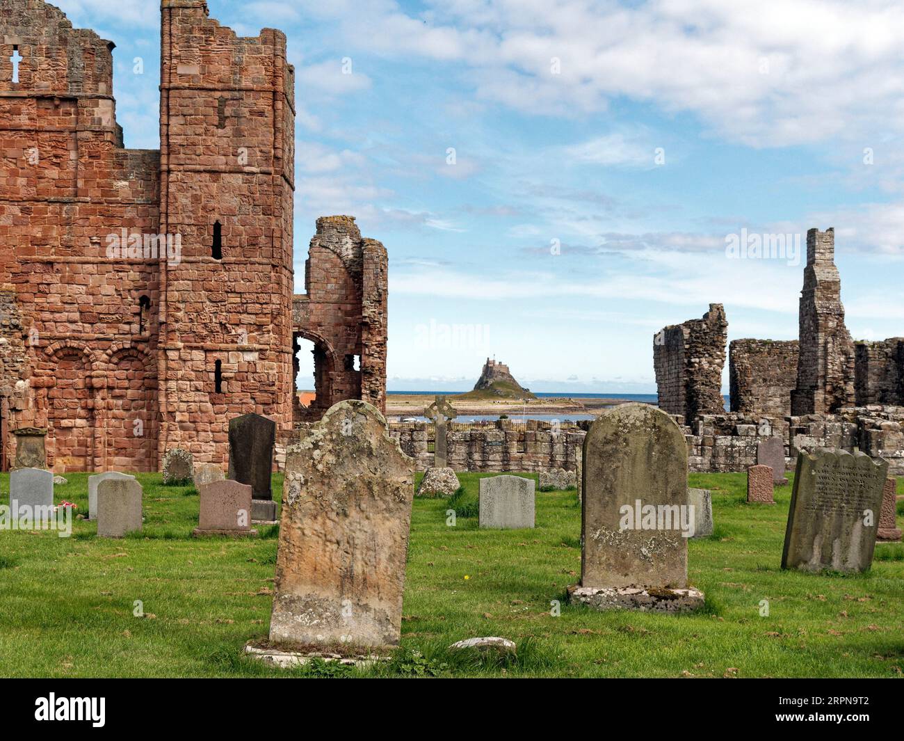 View from the grave yard of Lindisfarne church with the abbey runis and ...