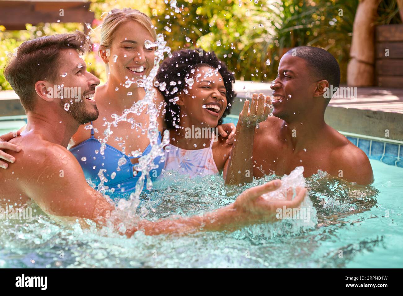 Group Of Smiling Multi-Cultural Friends On Holiday Splashing In ...