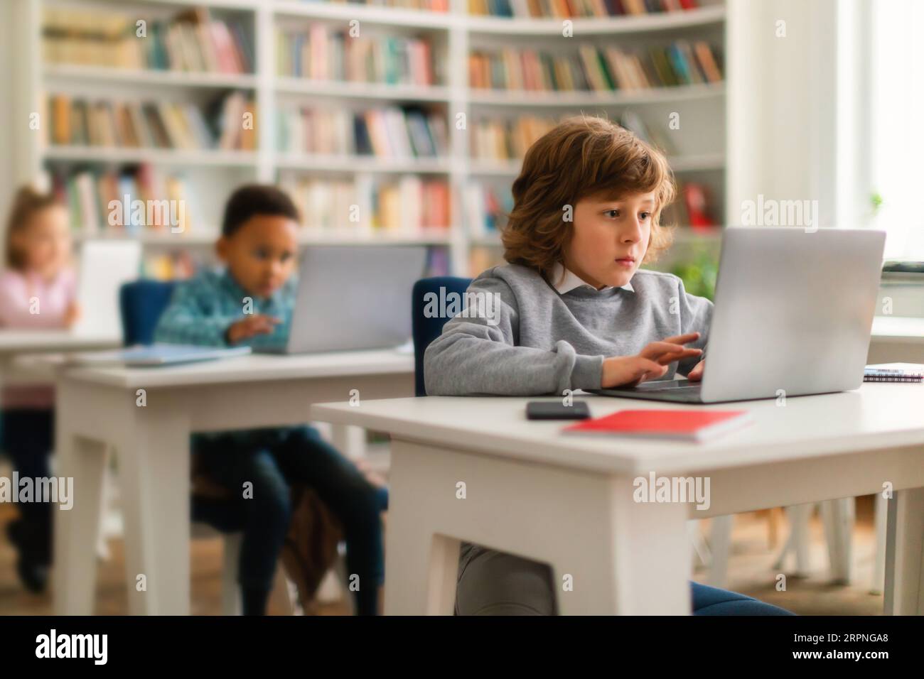 Computer science class. School boy sitting at desk at classroom with ...