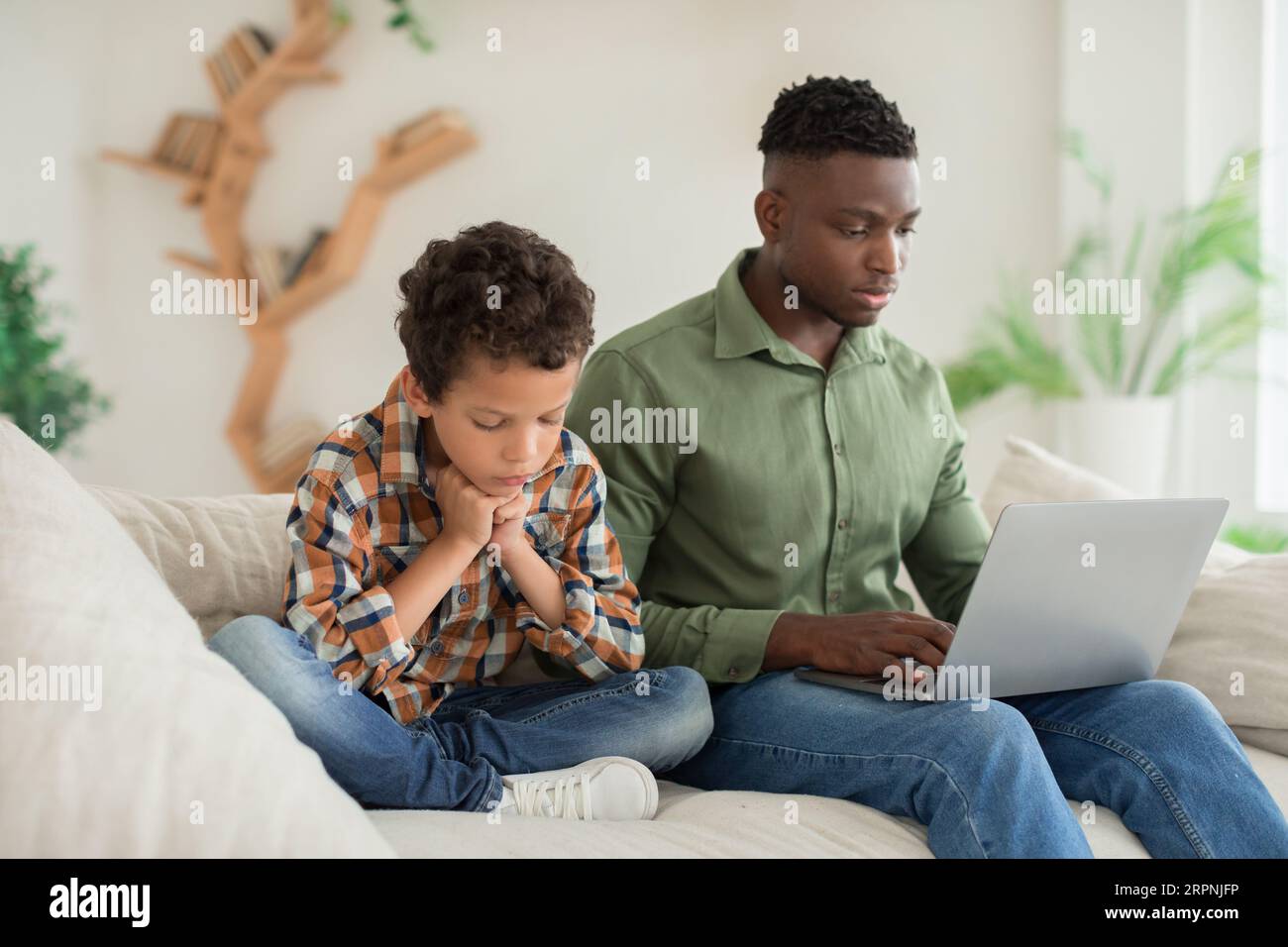 Black Young Father Ignoring Unhappy Little Son Using Laptop Indoor ...