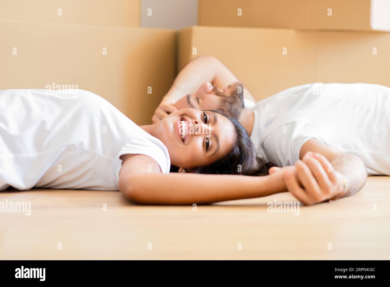 Loving young couple having break while packing stuff, relocation day ...