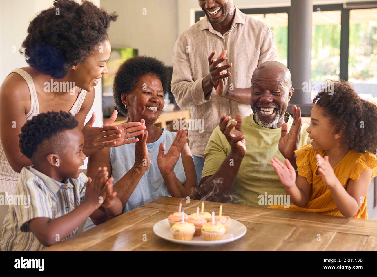 Multi-Generation Family Celebrate Grandmother's Birthday With Cake And ...