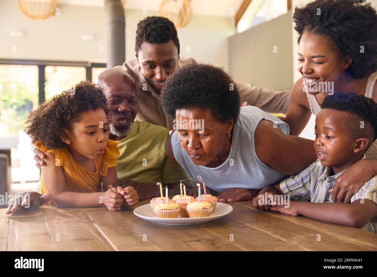 Multi-Generation Family Celebrate Grandmother's Birthday With Cake And ...