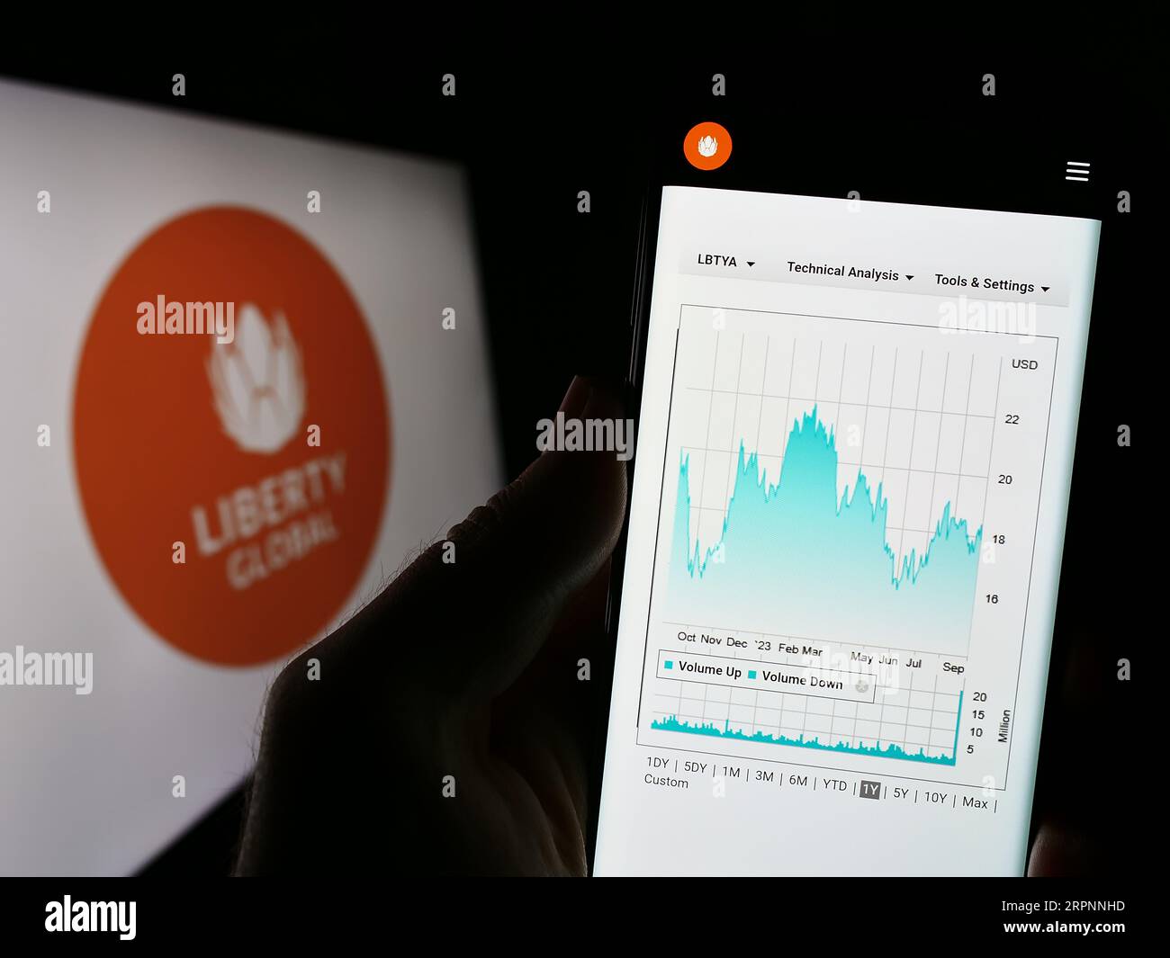 Person holding cellphone with webpage of telecommunications company ...