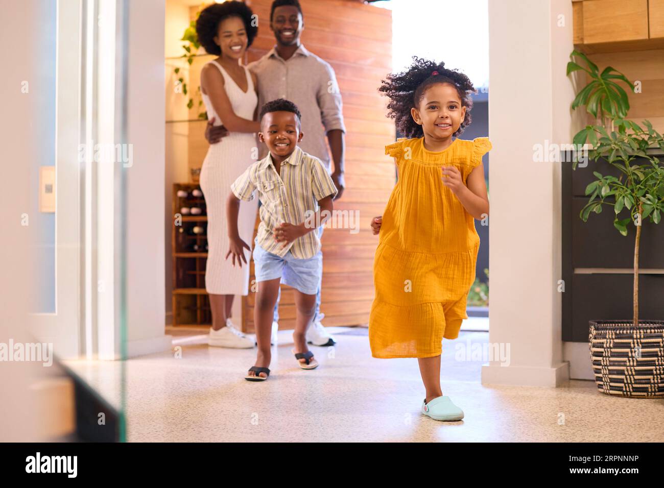 Family Returning Home Opening Front Door And Children Running In Stock ...