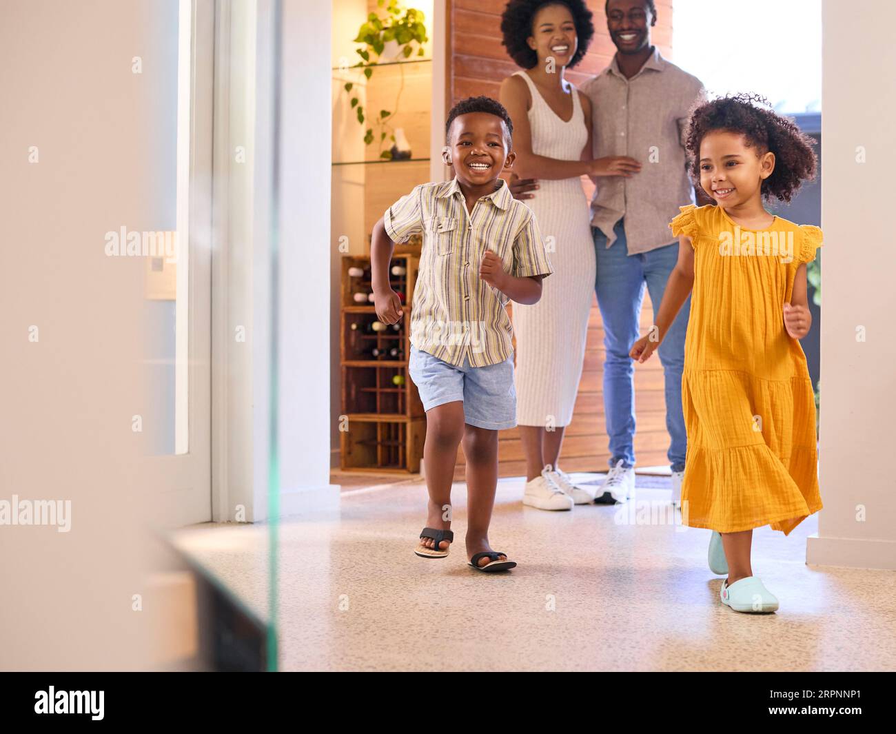Family Returning Home Opening Front Door And Children Running In Stock ...