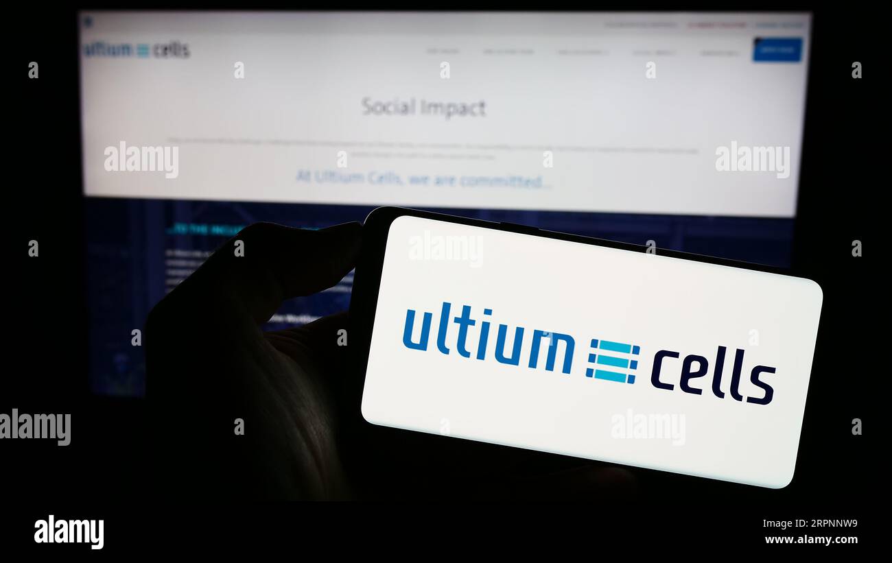 Person holding mobile phone with logo of American EV battery company ...