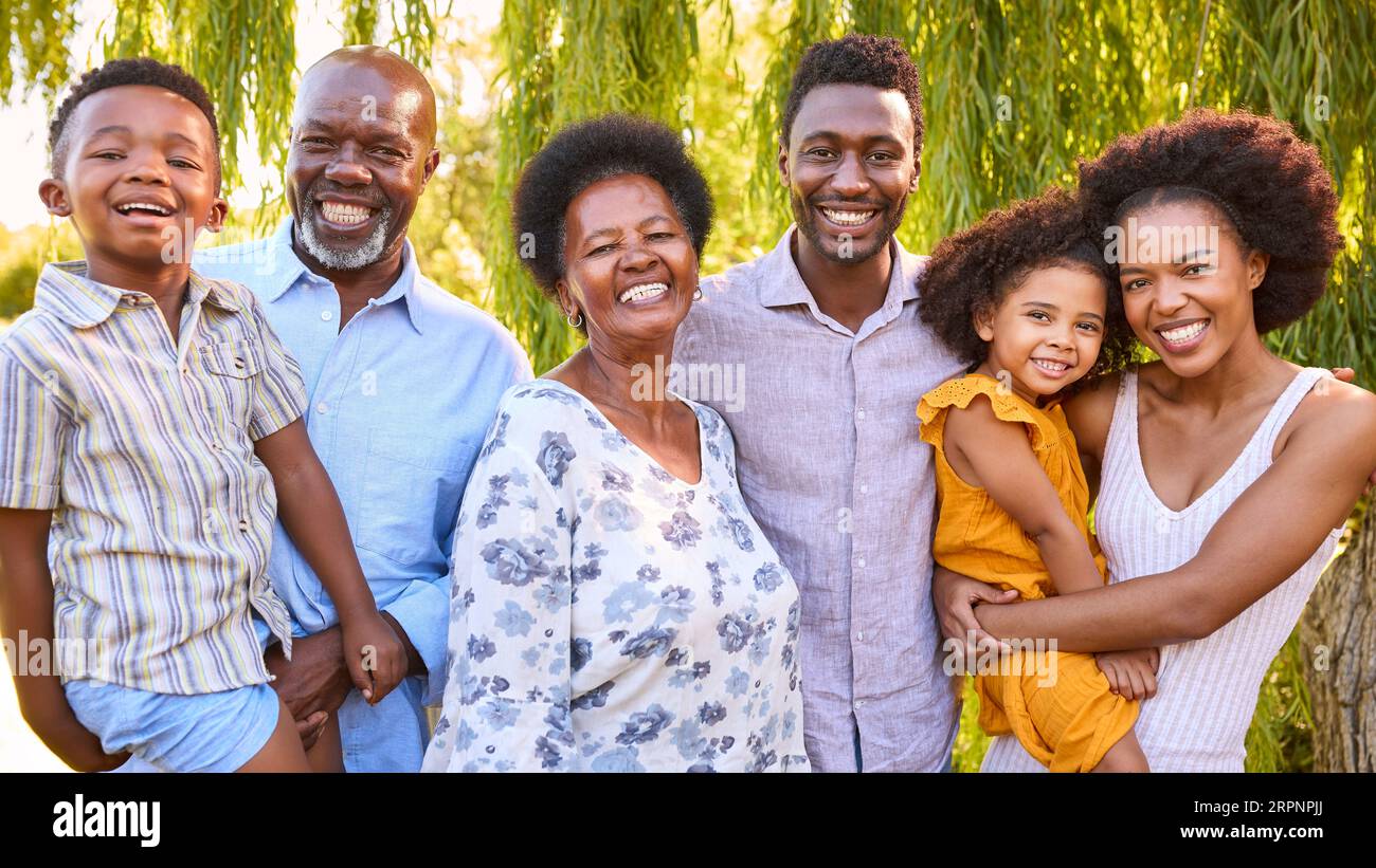 Portrait Of Multi-Generation Family Standing In Garden Smiling At ...