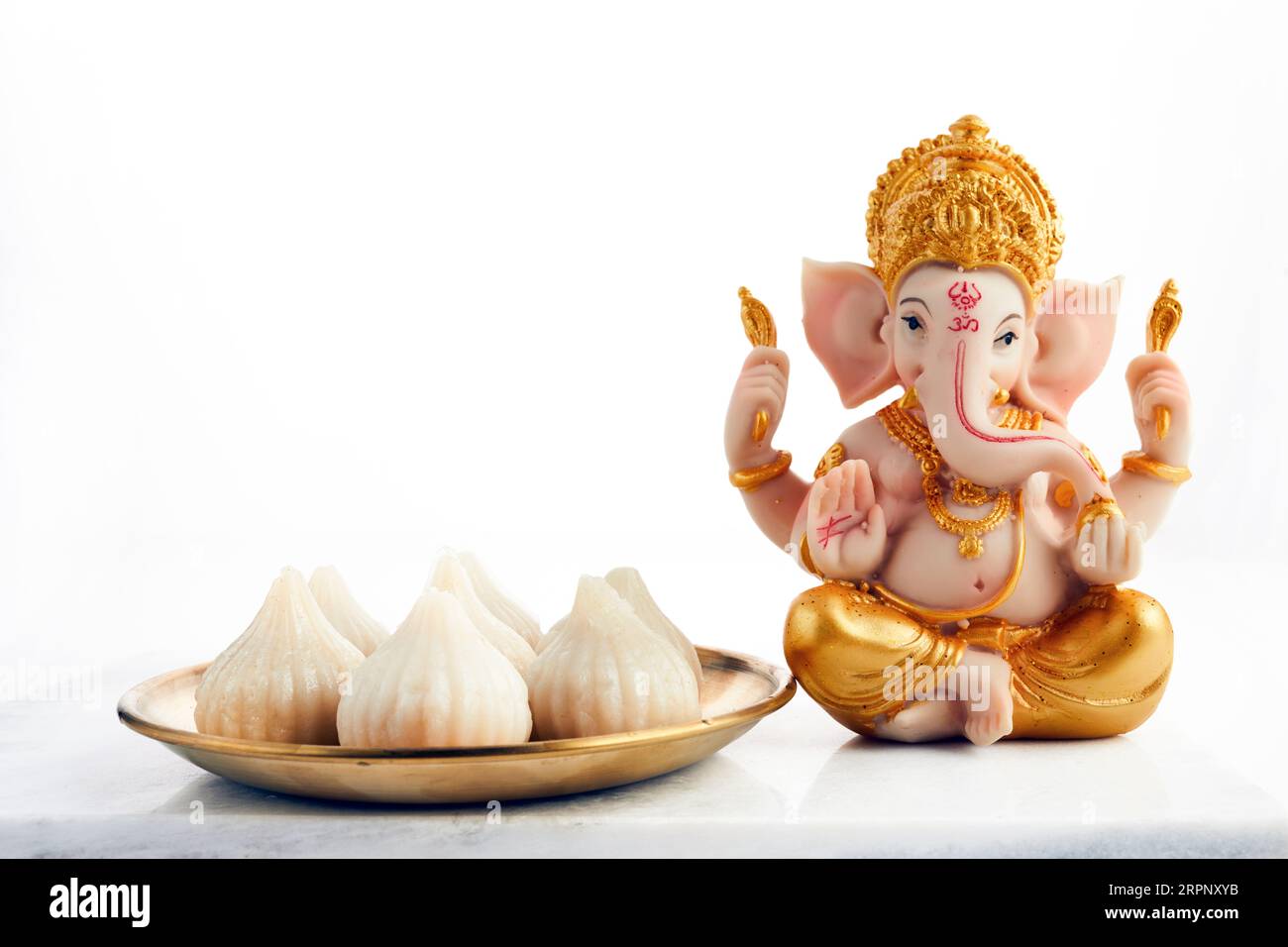 Idol of lord Ganesha with Modak Sweet Dish and flower. Ganesh chaturthi ...
