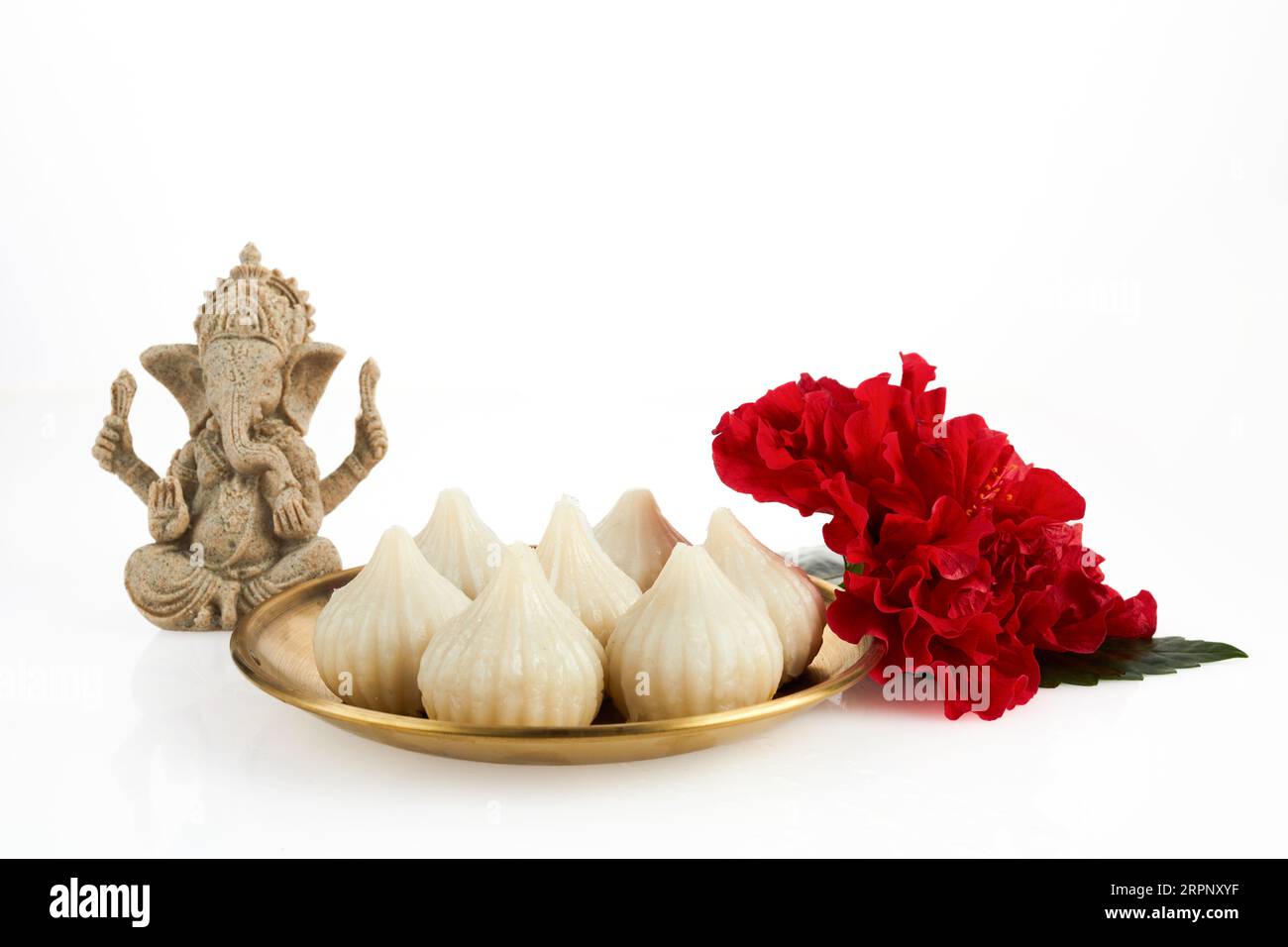 Idol of lord Ganesha with Modak Sweet Dish and flower. Ganesh chaturthi ...