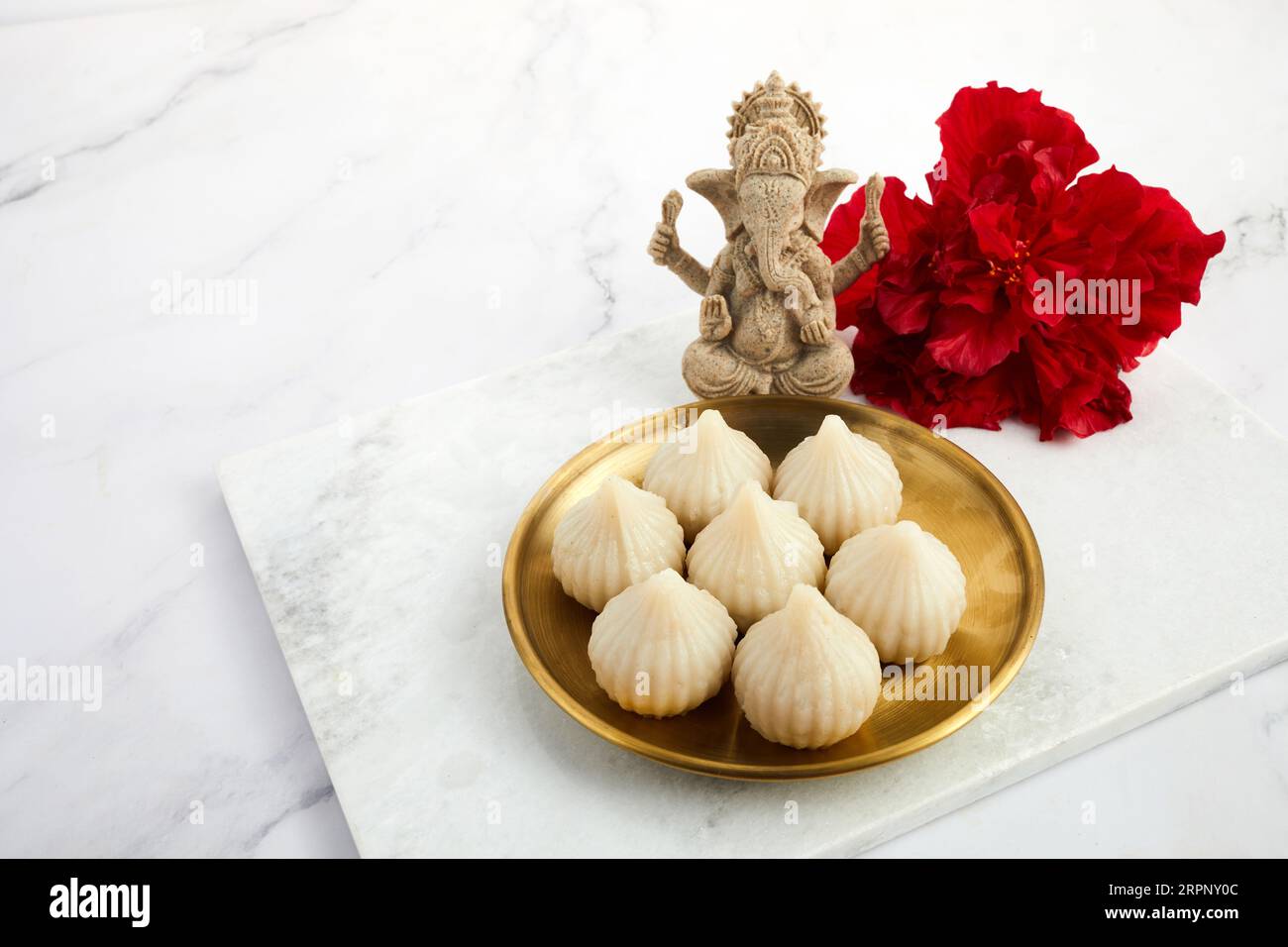Idol of lord Ganesha with Modak Sweet Dish and flower. Ganesh chaturthi ...