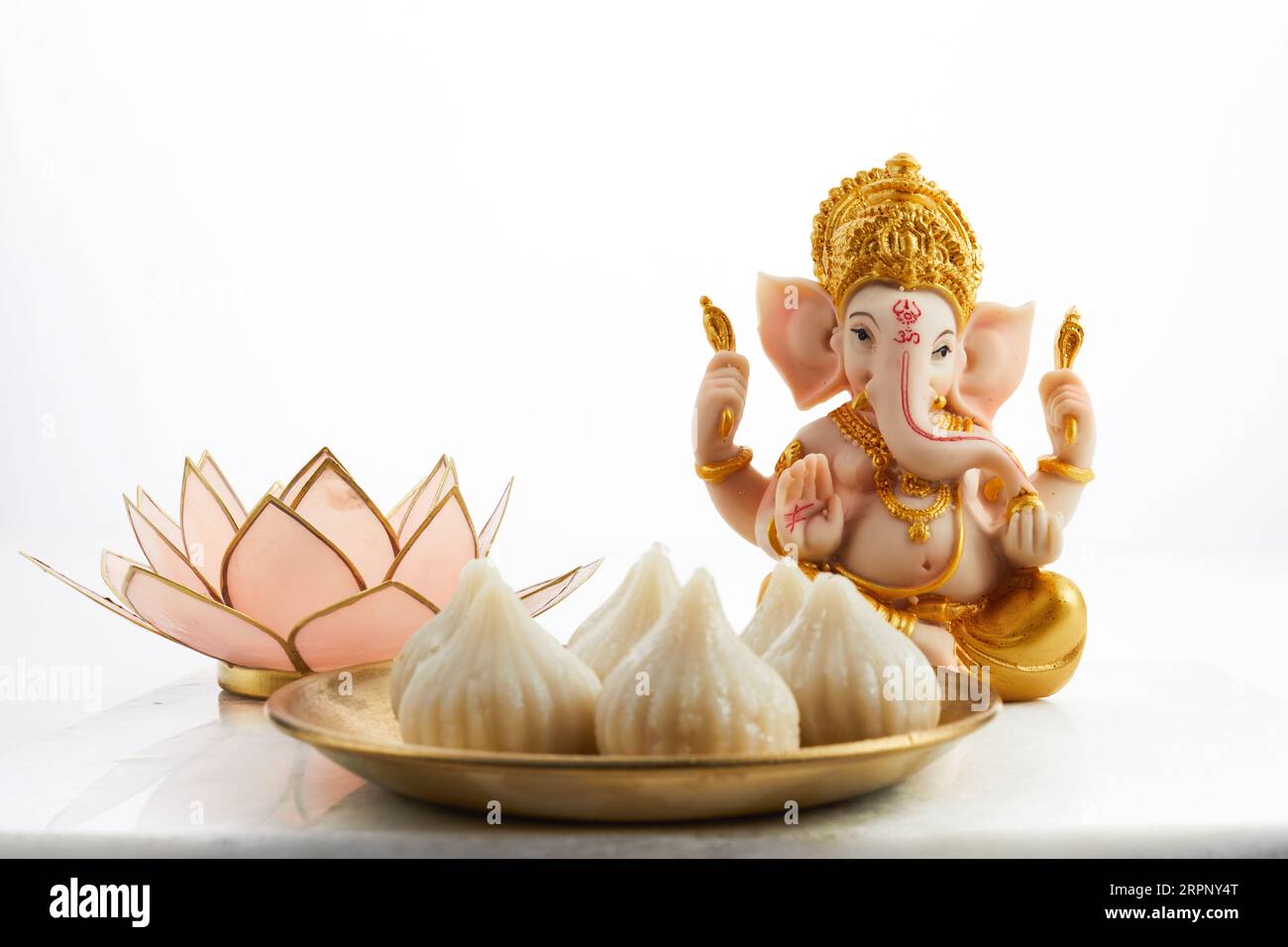 Idol of lord Ganesha with Modak Sweet Dish and flower. Ganesh chaturthi ...