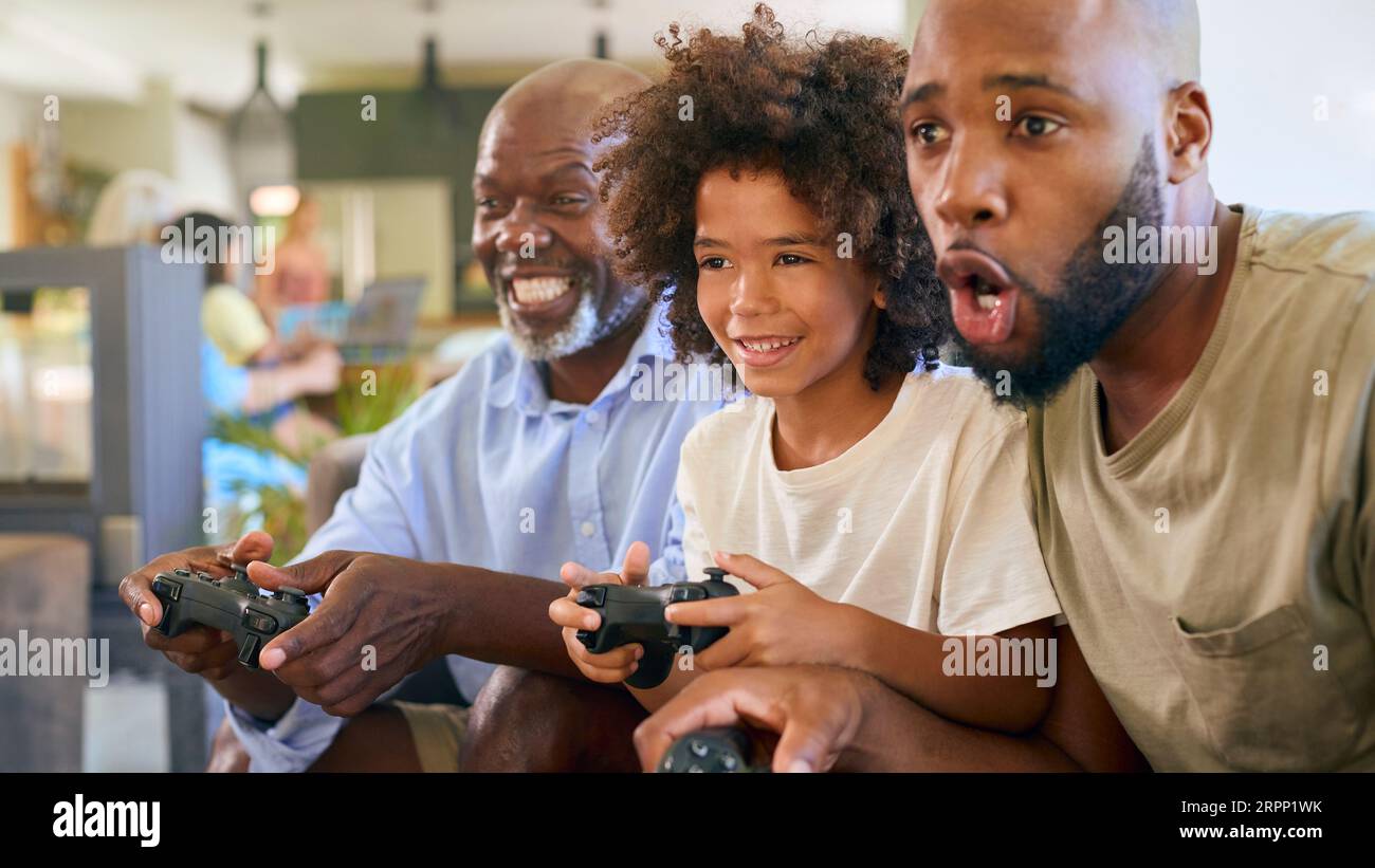 Multi-Generation Male Family Having Fun Playing Computer Game Sitting ...