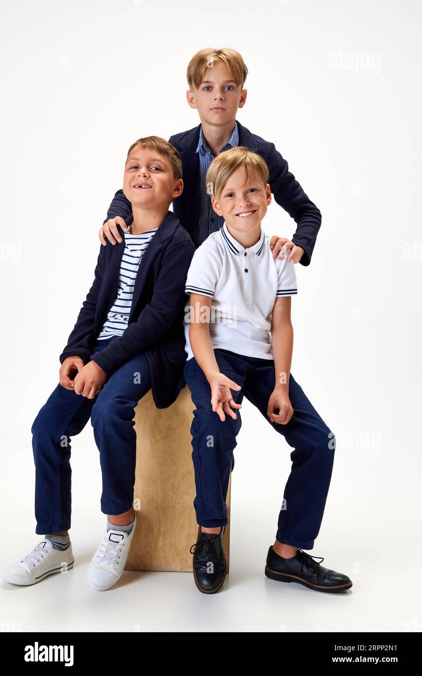 Boys, children, classmates in stylish school uniform against white ...