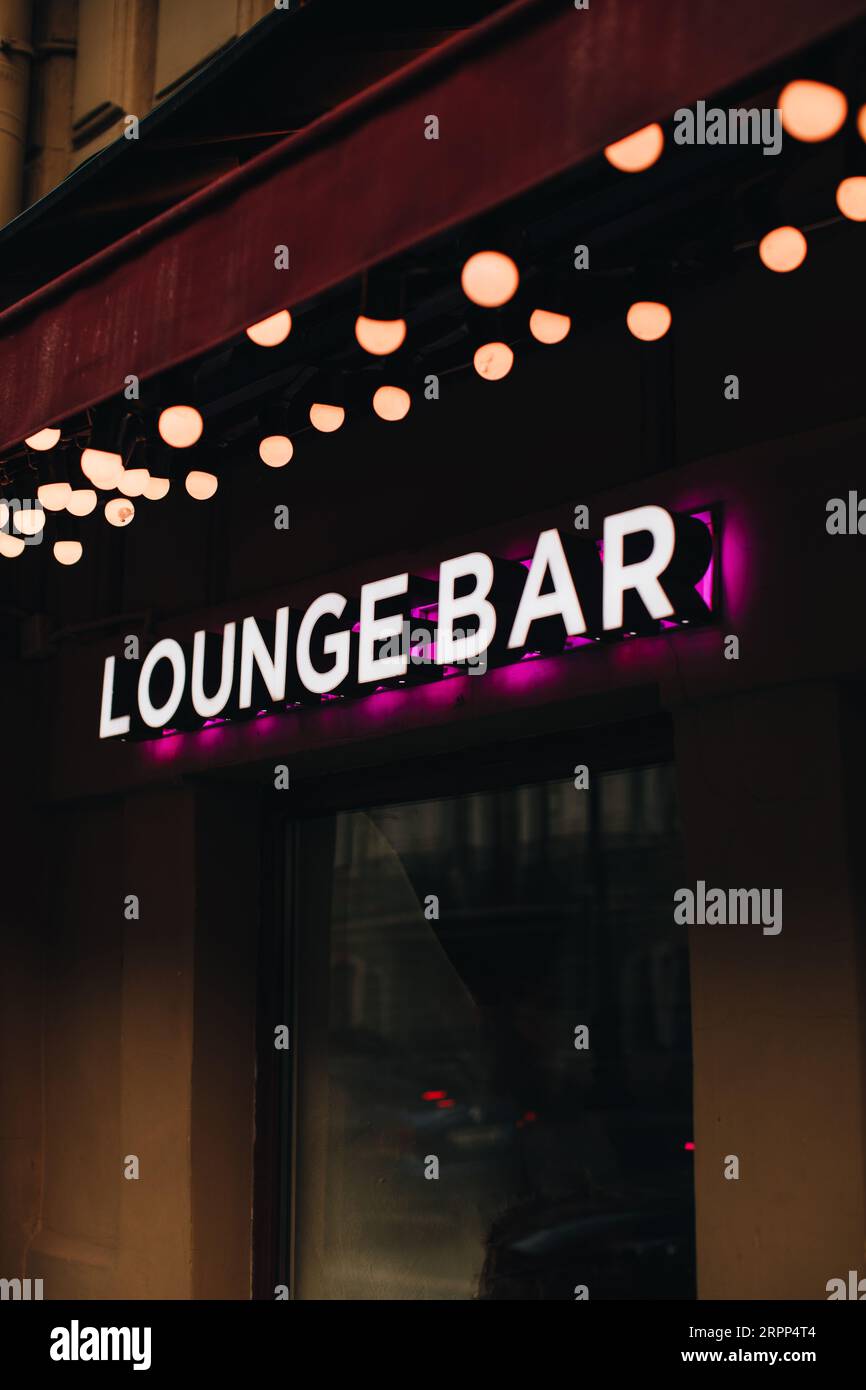 Neon sign on a black background, the inscription Lounge bar with pink ...