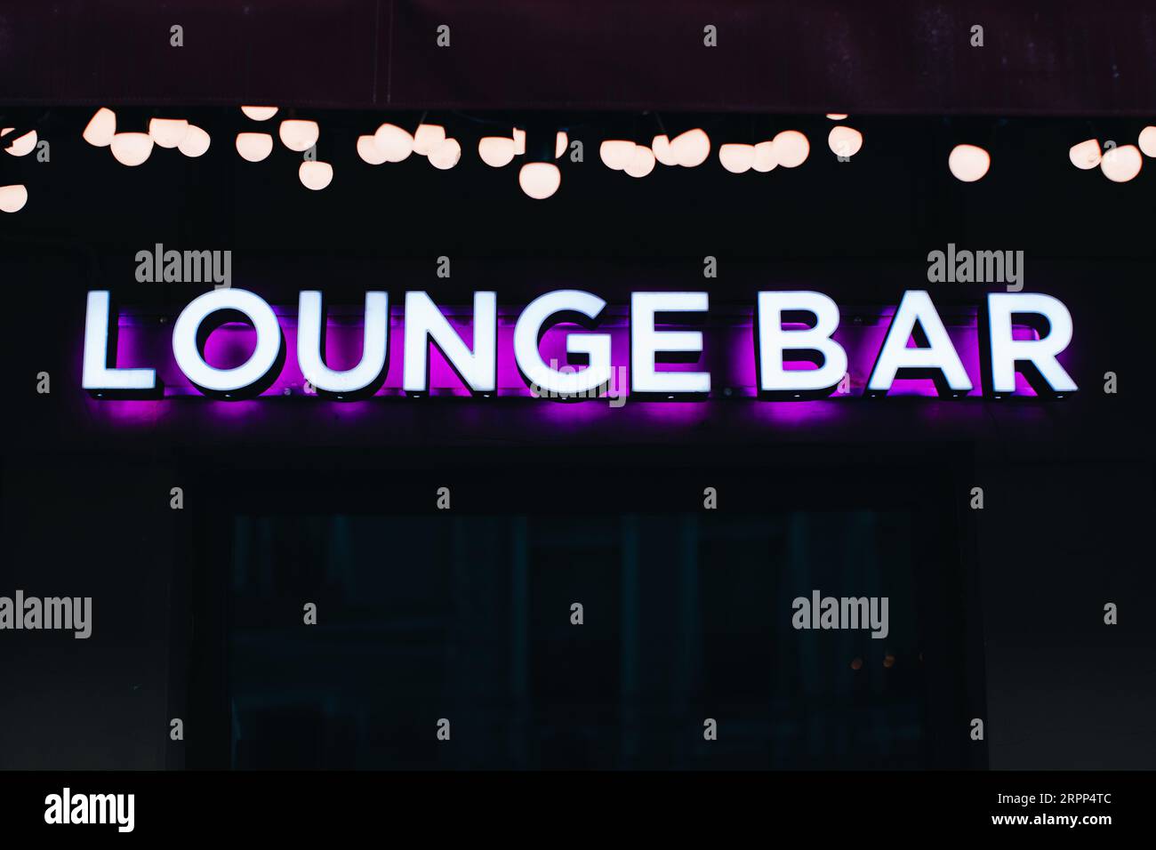 Neon sign on a black background, the inscription Lounge bar with purple ...
