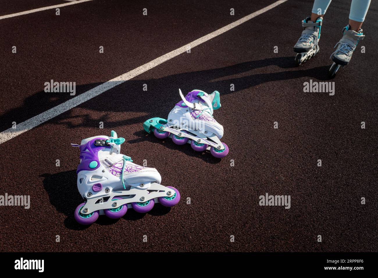 white roller skates lie on the track against the background of a roller ...