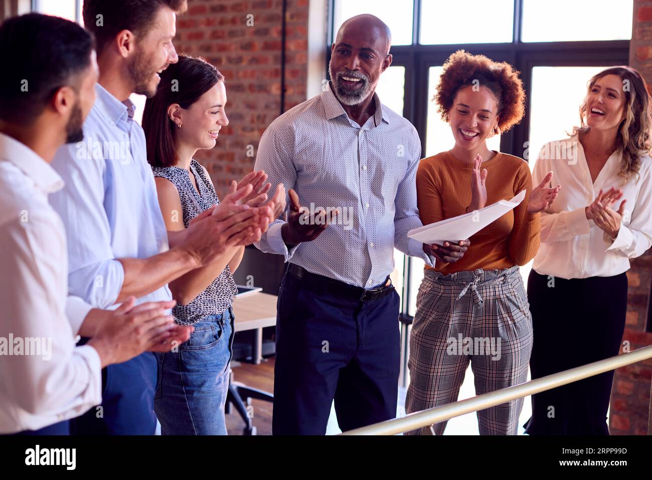 Colleagues Applauding Businessman Leading Team Meeting In Busy Multi ...