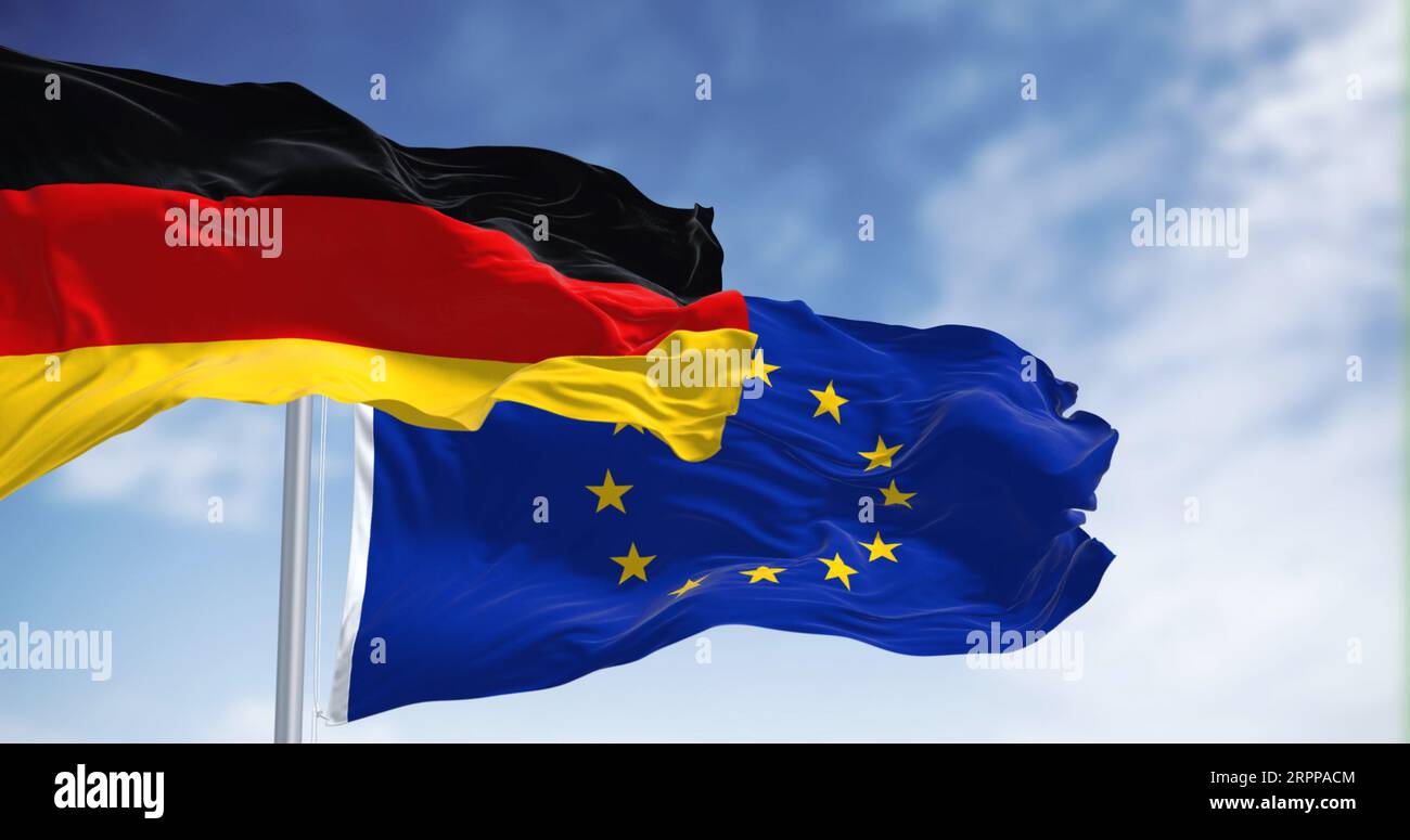 Flags of Germany and the European Union waving in the wind on a clear ...
