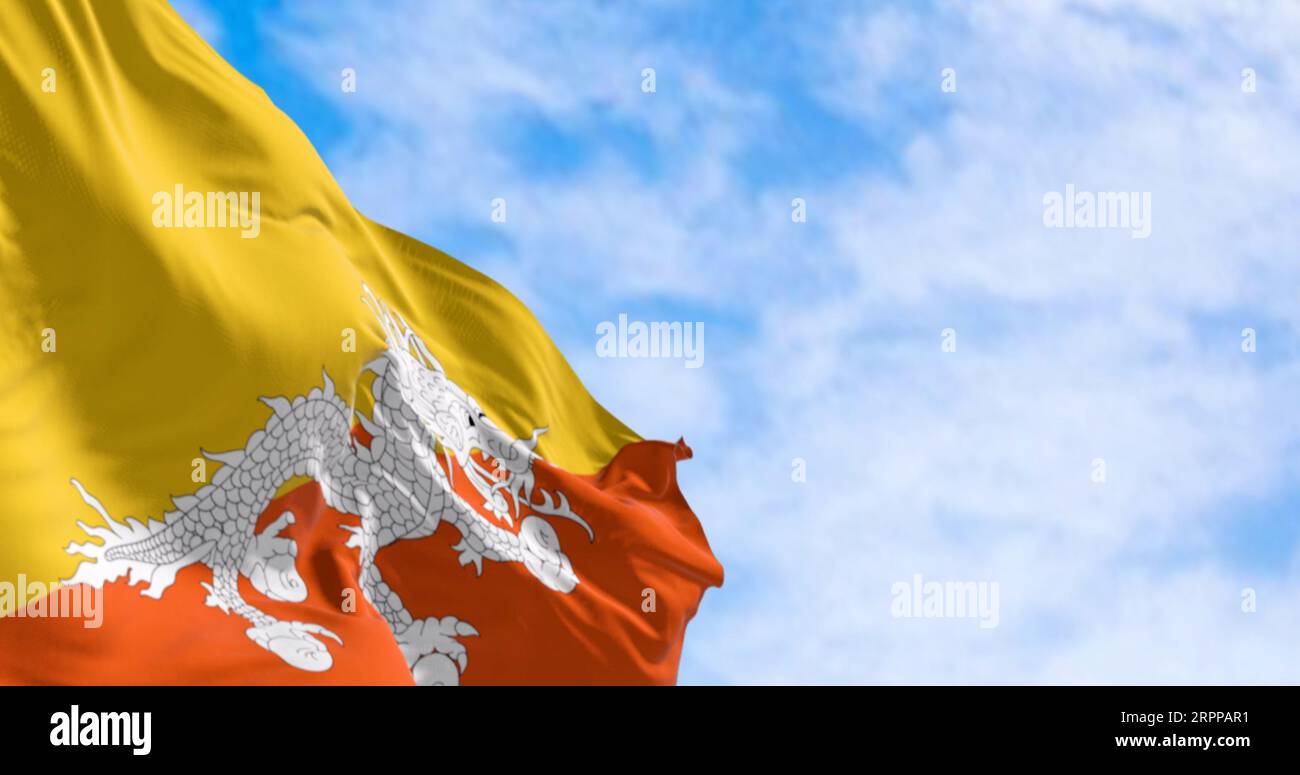 National flag of Bhutan waving in the wind on a clear day. Yellow upper ...