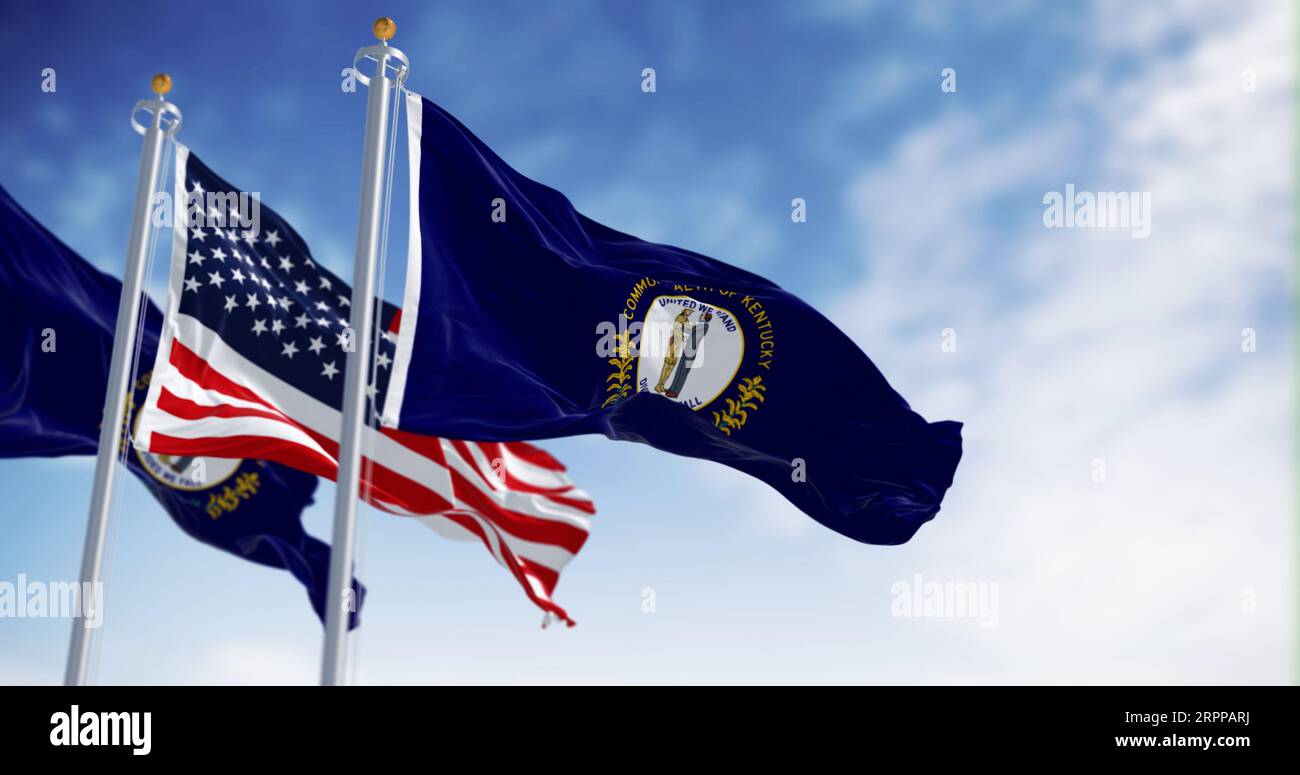 Flags of Kentucky and the United States waving in the wind on a clear ...