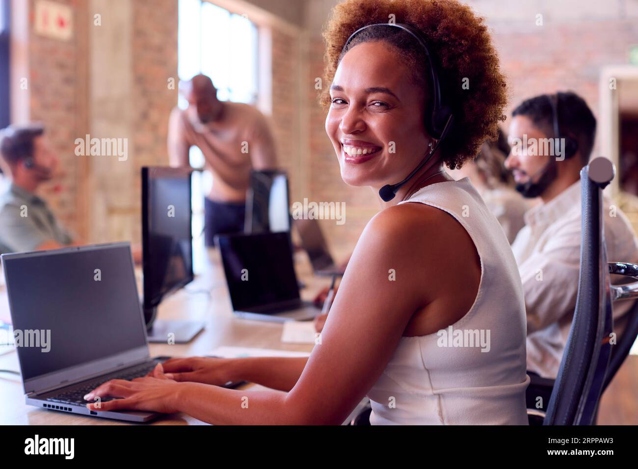 Businesswoman In Multi-Cultural Business Team Wearing Headsets In Customer Support Centre Stock ...