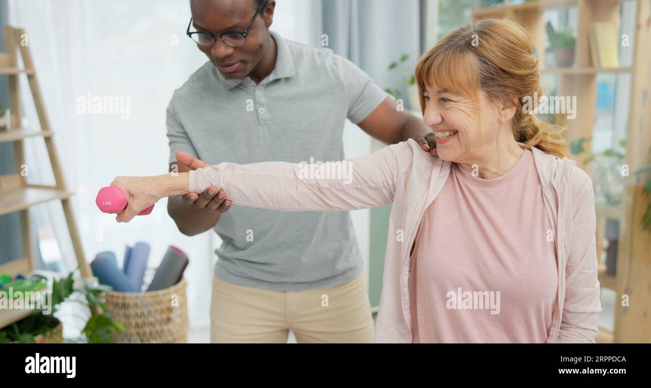 Physiotherapy, fitness and senior woman with black man and dumbbell for ...