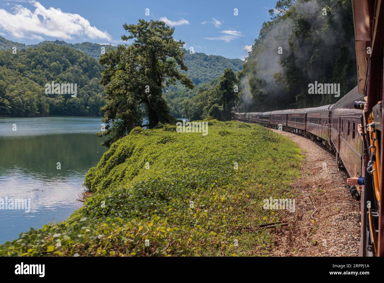 Steam from the Great Smoky Mountains Railroad hangs in the air as the ...