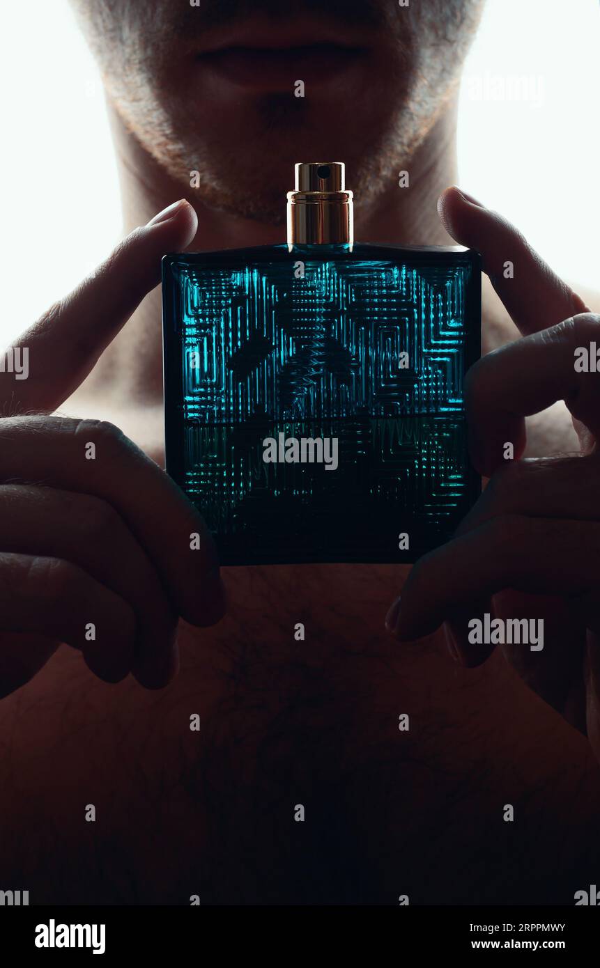 Men's perfume. Man holds perfume Stock Photo - Alamy