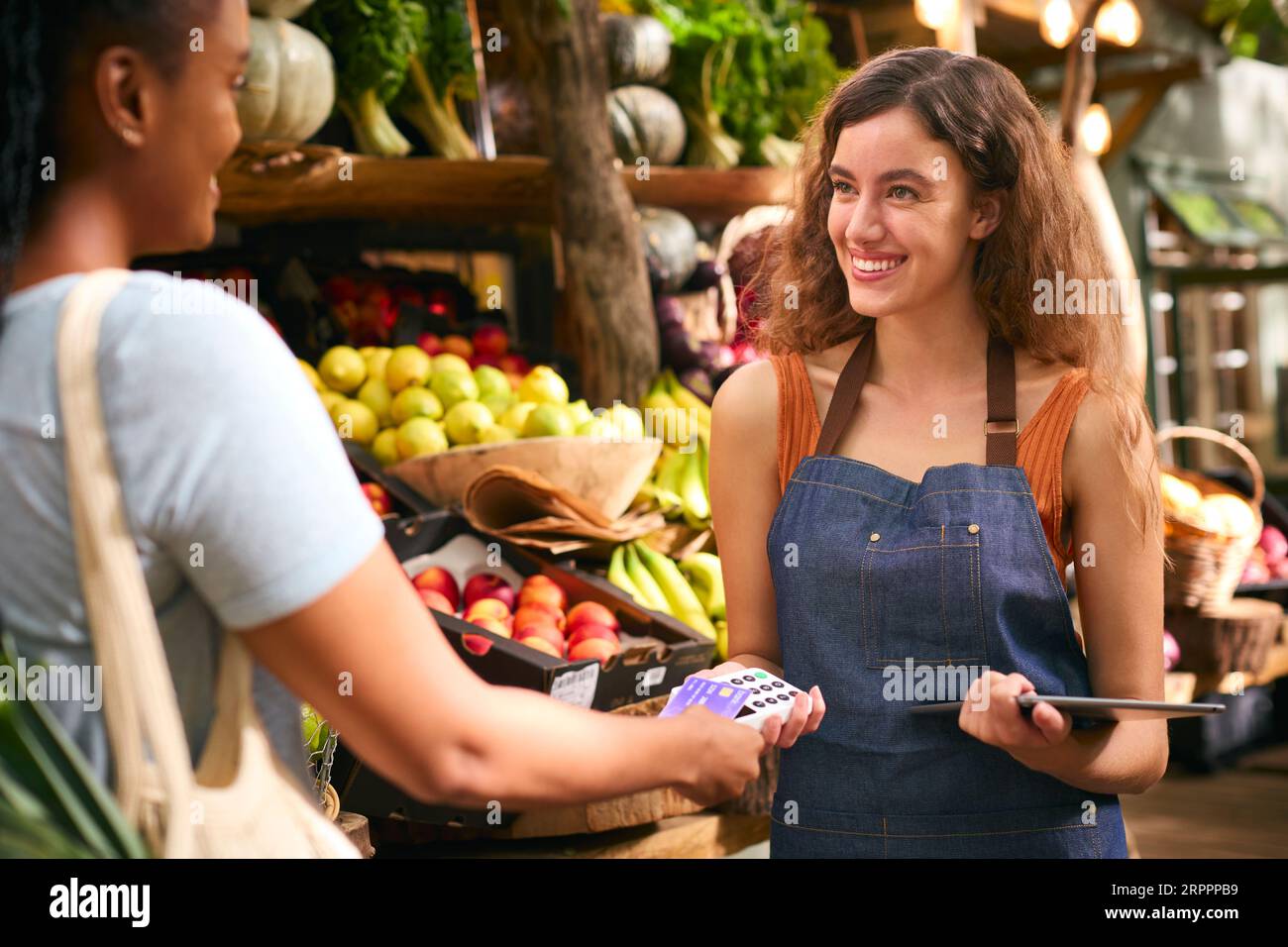 Female Customer At Market Stall Paying For Produce With Contactless ...