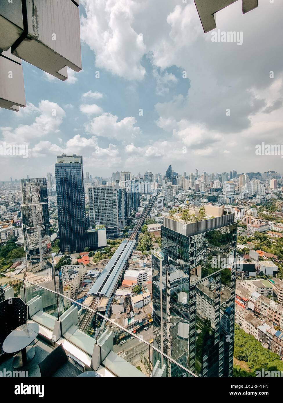An aerial view of a modern cityscape featuring a glass-paneled balcony ...