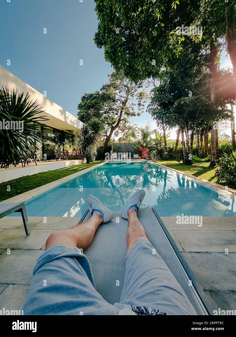 A person lies in a relaxed position, their legs extended in front of ...